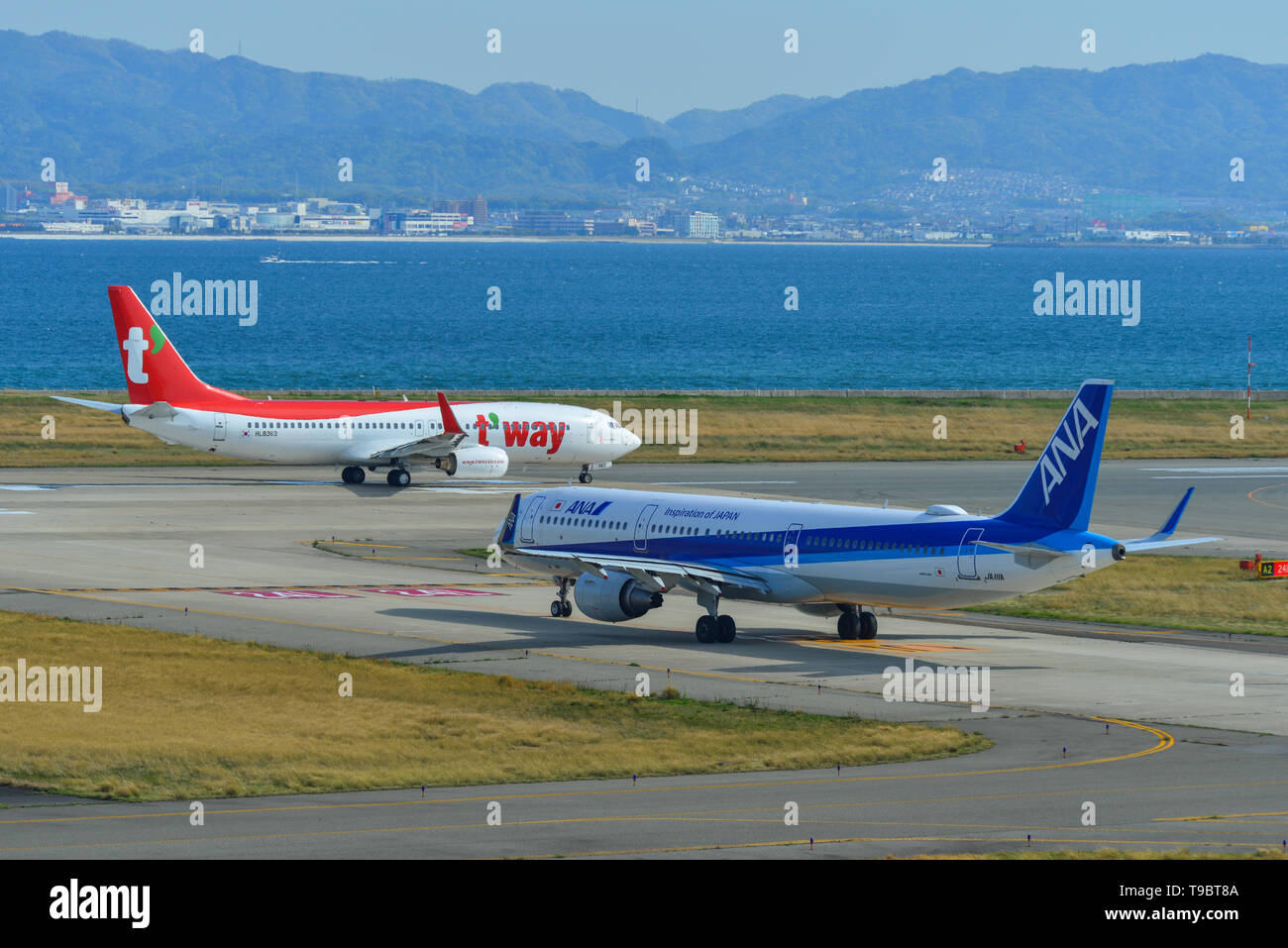 Osaka, Japan - Apr 19, 2019. Passenger airplanes taxiing on runway of ...