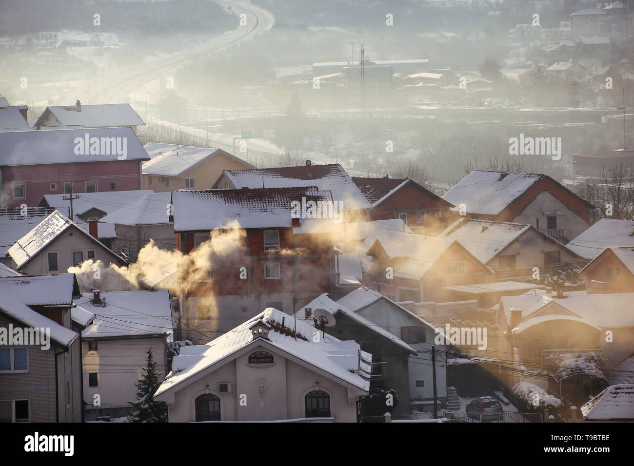 Smoking chimneys at roofs with snow of houses emits smoke, smog at ...