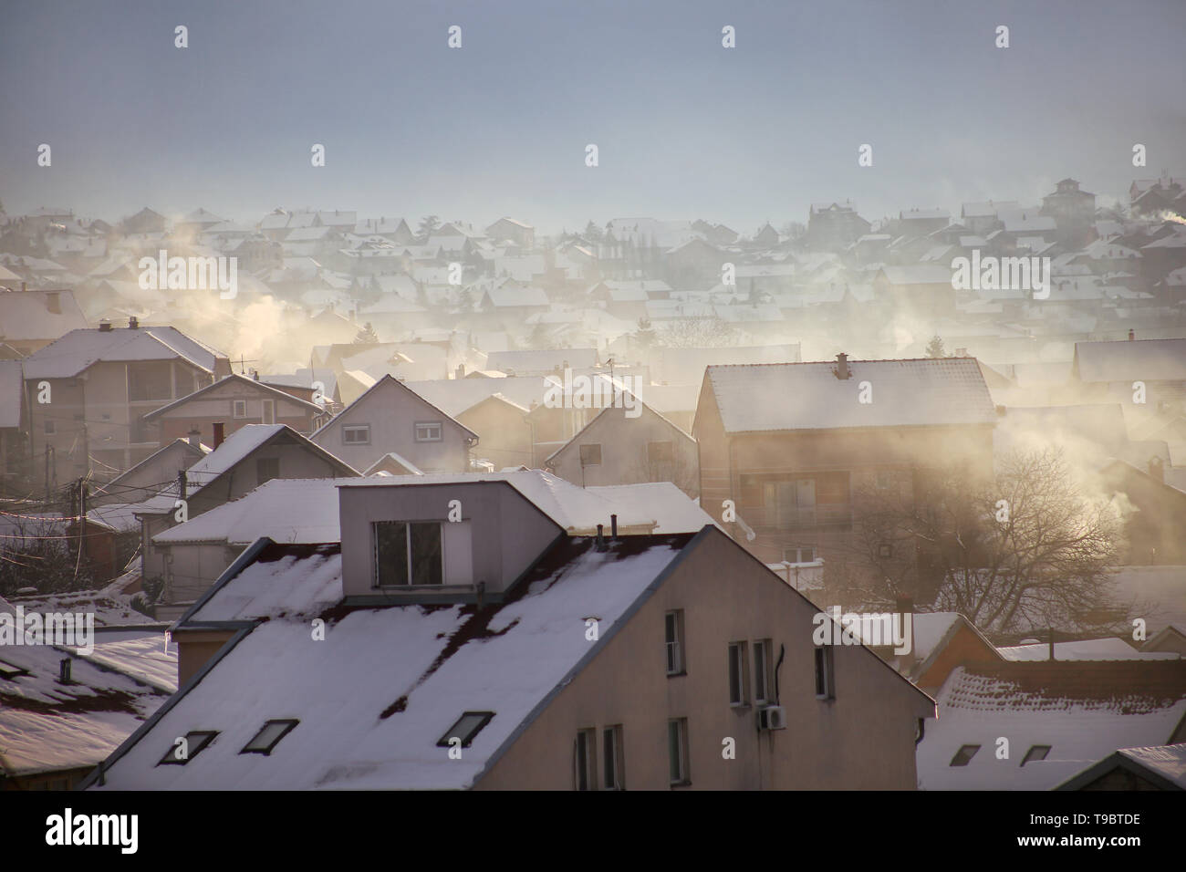 Smoking chimneys at roofs with snow of houses emits smoke, smog at ...