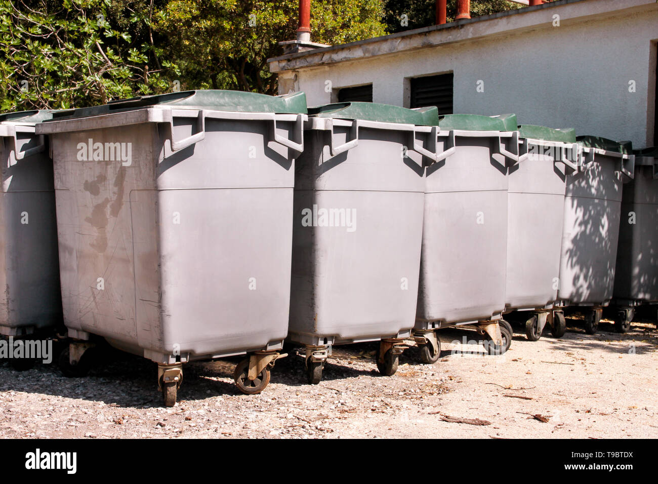 Large garbage containers, trash dumpsters and bins standing in row ...