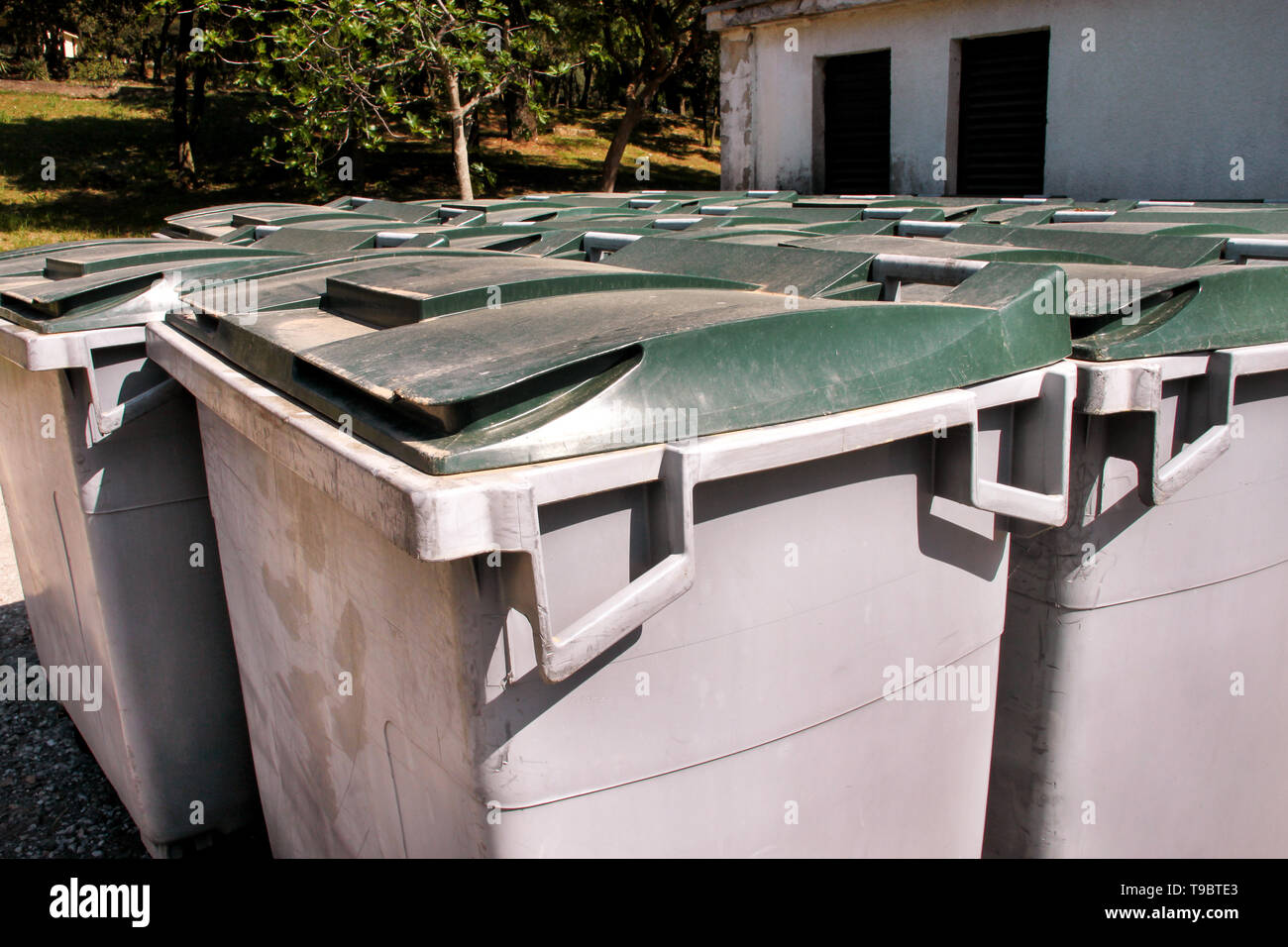 Large garbage containers, trash dumpsters and bins standing in row ...