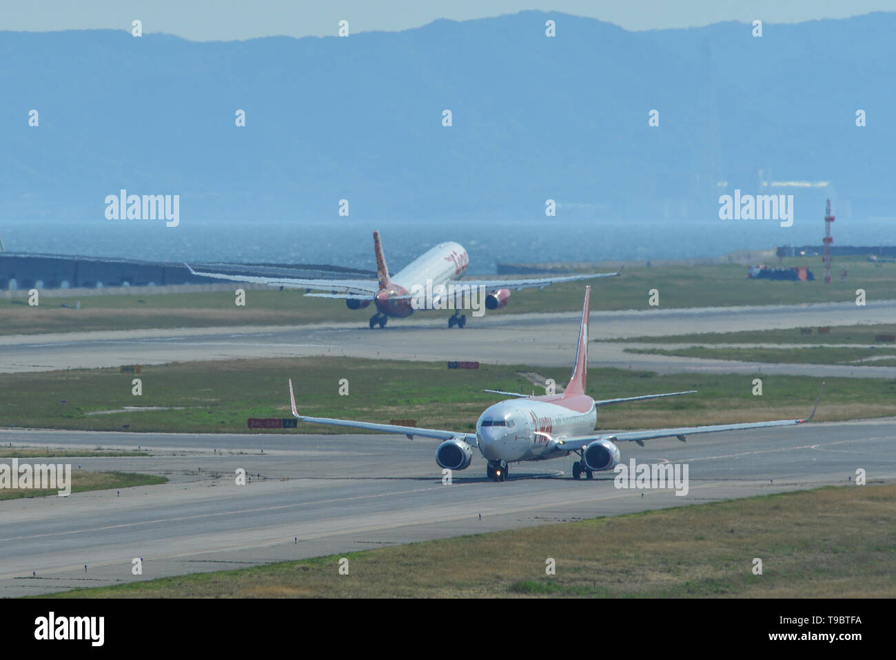 Osaka, Japan - Apr 19, 2019. Passenger airplanes taxiing on runway of ...