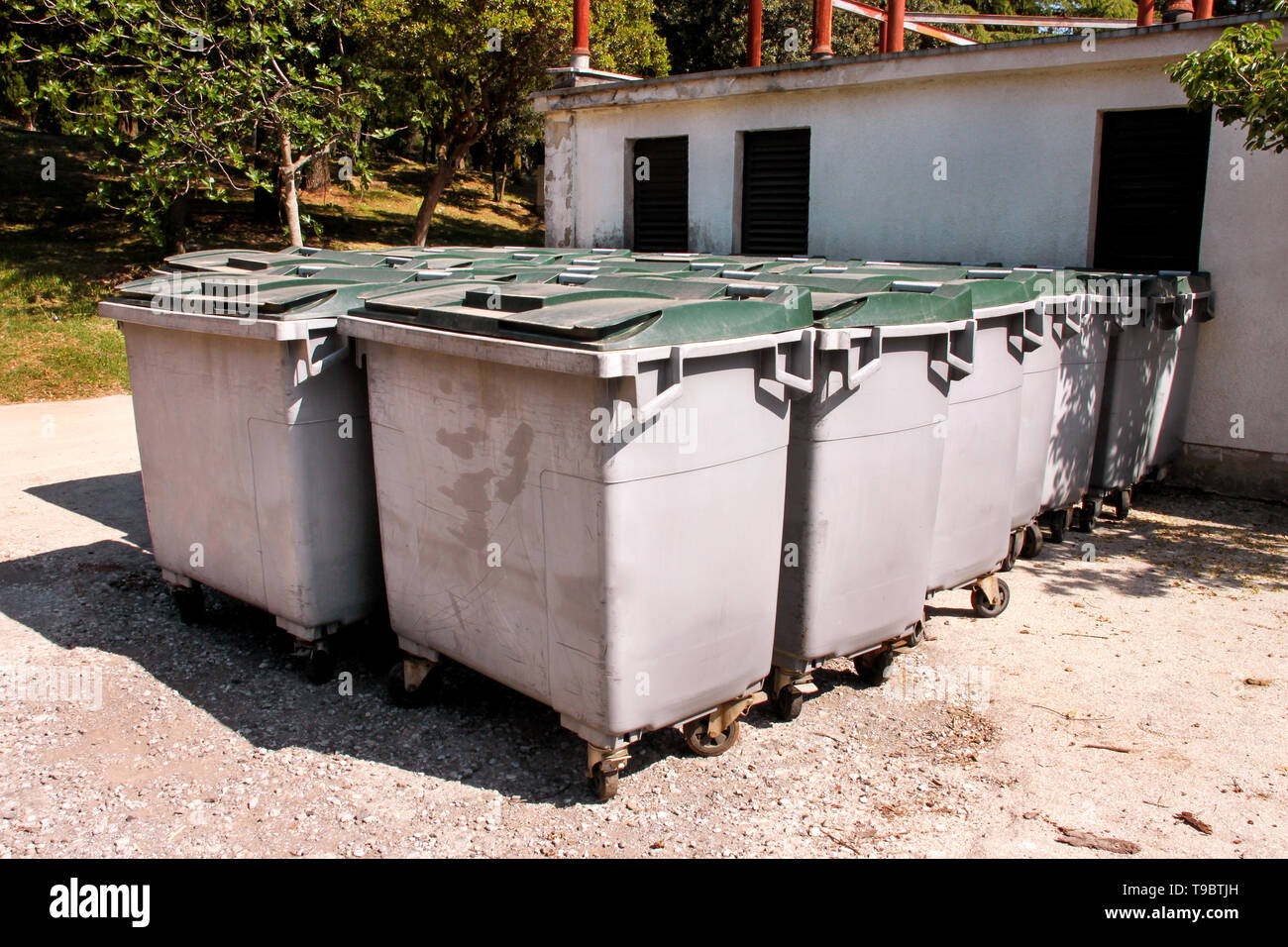 Large garbage containers, trash dumpsters and bins standing in row ...