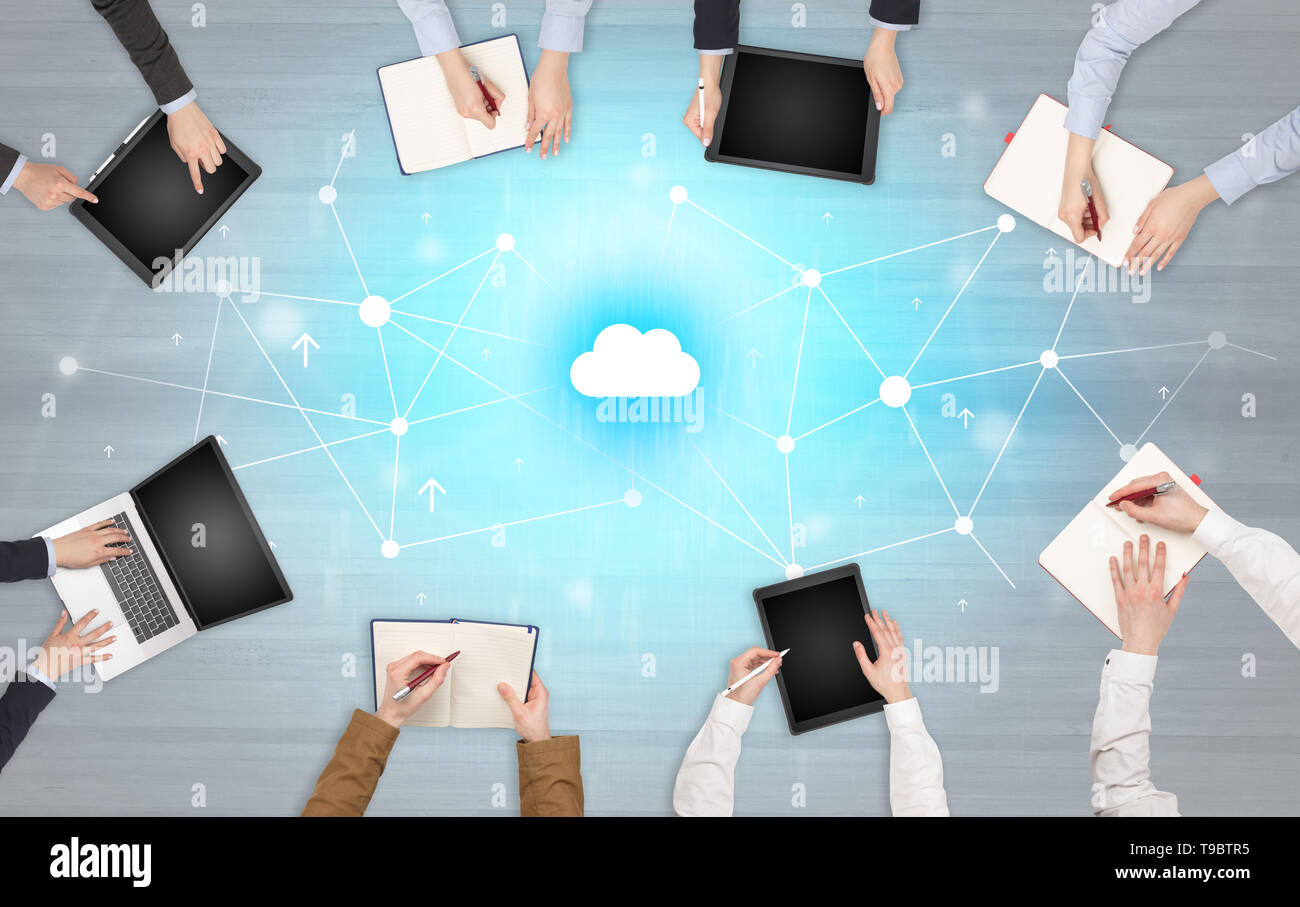 Group of people with devices in hands working in team on tablets ...