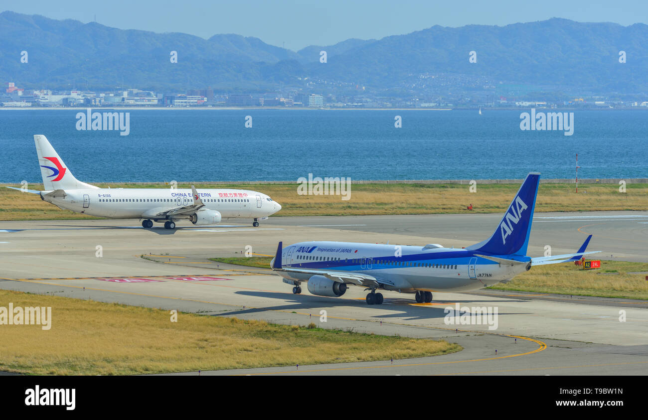 Osaka, Japan - Apr 19, 2019. Passenger airplanes taxiing on runway of ...
