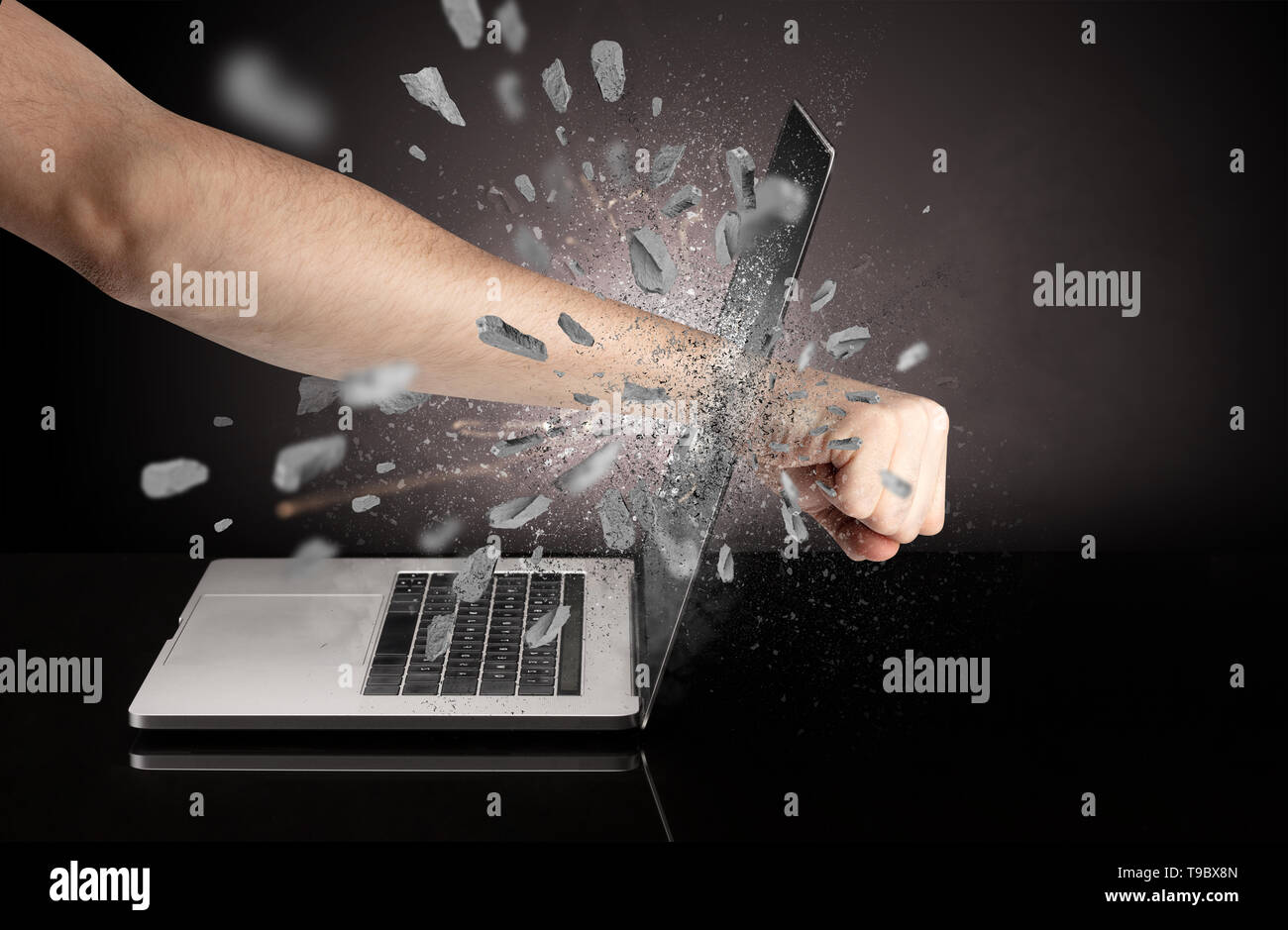 Strong male hand breaks laptop screen Stock Photo - Alamy