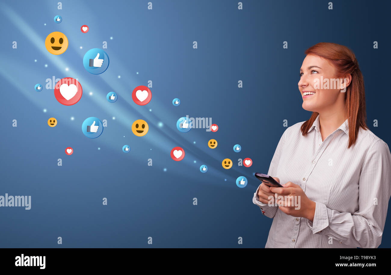 Young person using smartphone with flying social media icons around ...