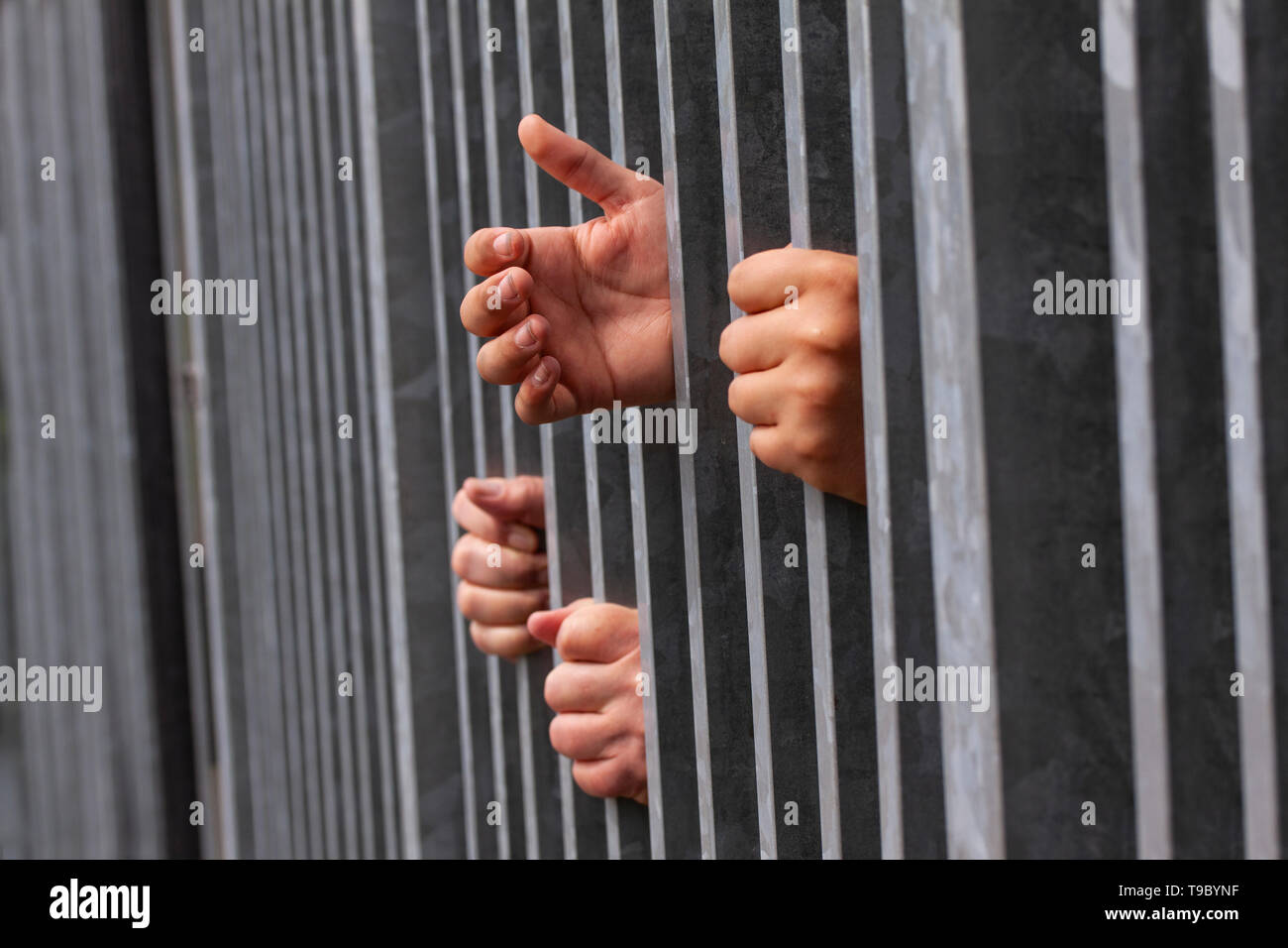 Jail bars hands hi-res stock photography and images - Alamy