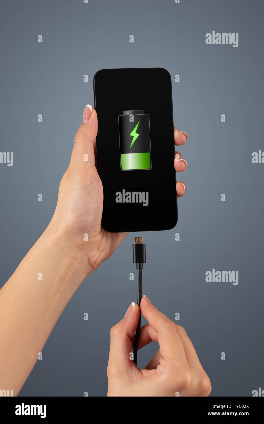 Elegant hand charging cellphone with low battery Stock Photo - Alamy