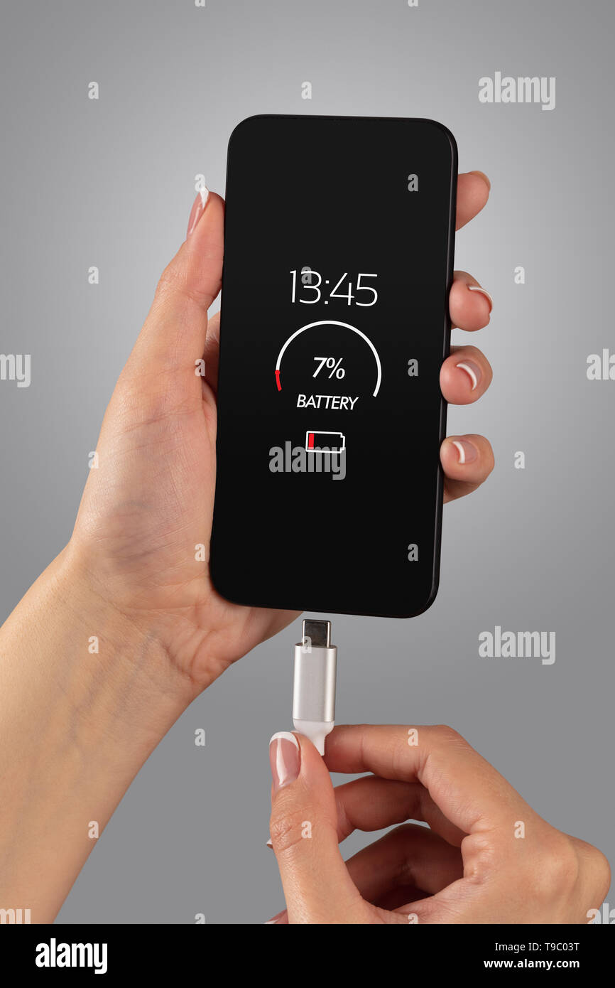 Elegant hand charging cellphone with low battery Stock Photo - Alamy