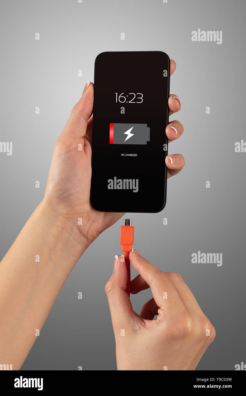 Elegant hand charging smartphone with low battery Stock Photo - Alamy