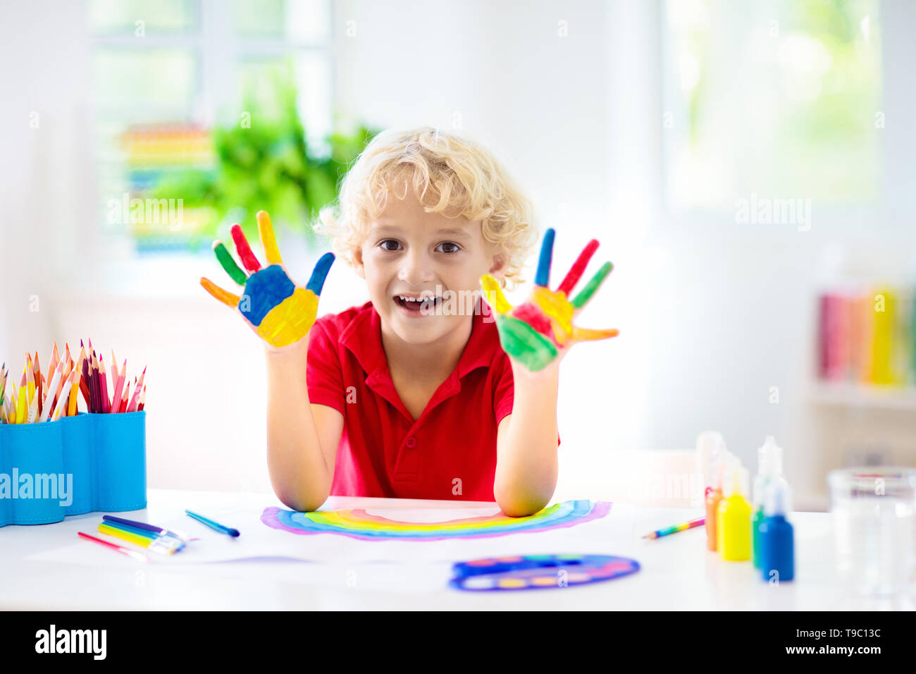 Kids paint. Child painting in white sunny study room. Little boy ...