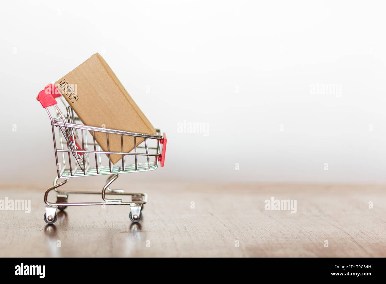 Shopping cart with carboard box Stock Photo - Alamy