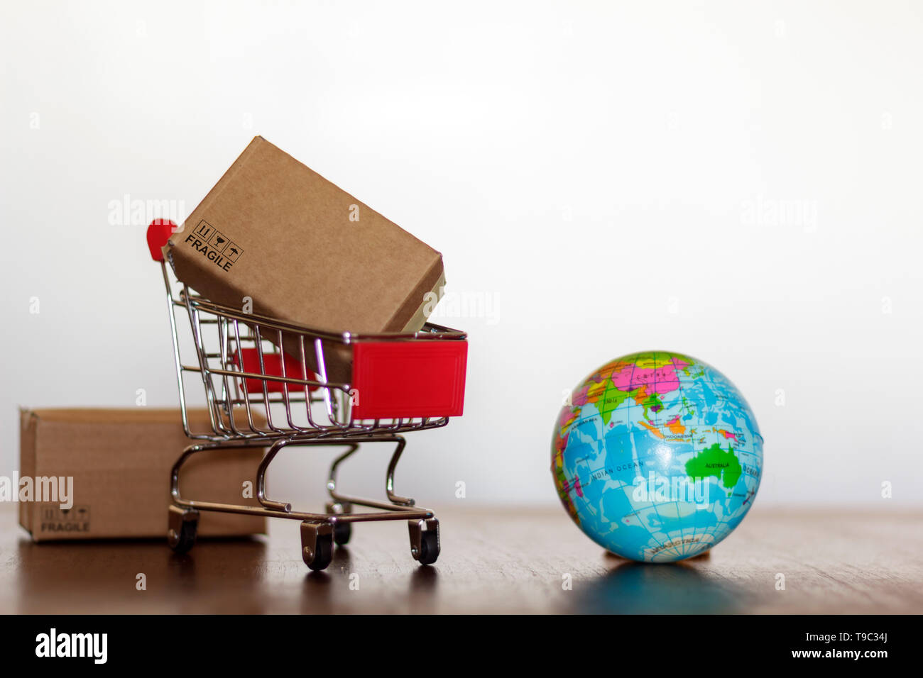 Shopping Trolley with carton and earth globe. Worldwide shopping and ...