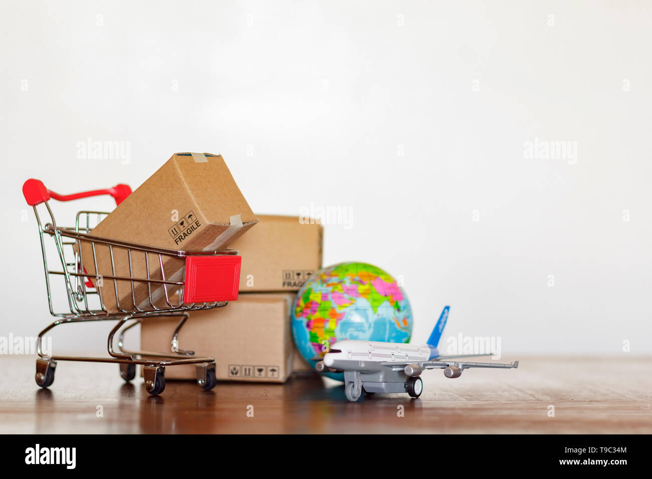 Shopping cart with cartons, airplane and earth globe. Global logistics ...