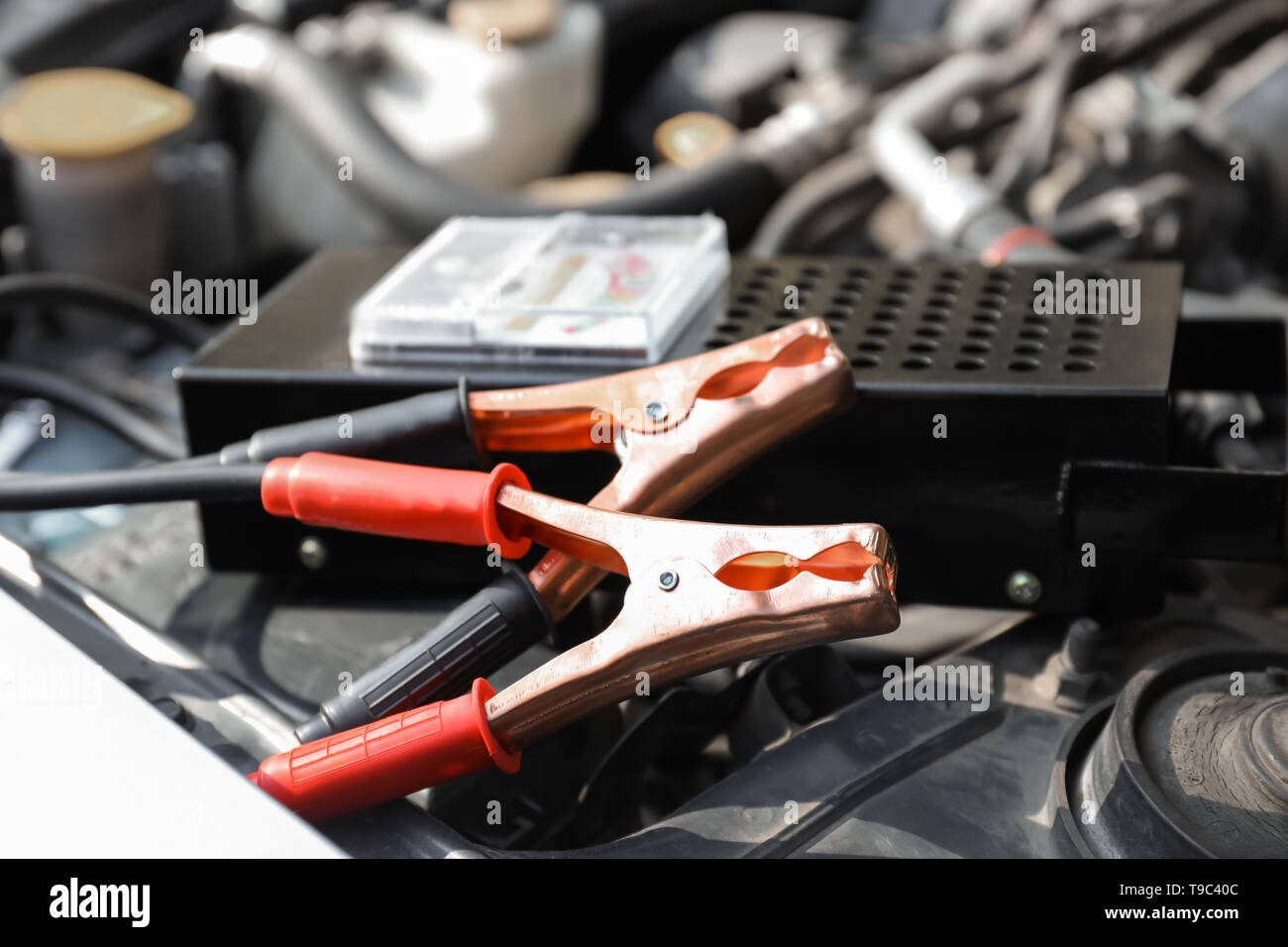 Battery charger under open hood of car Stock Photo - Alamy