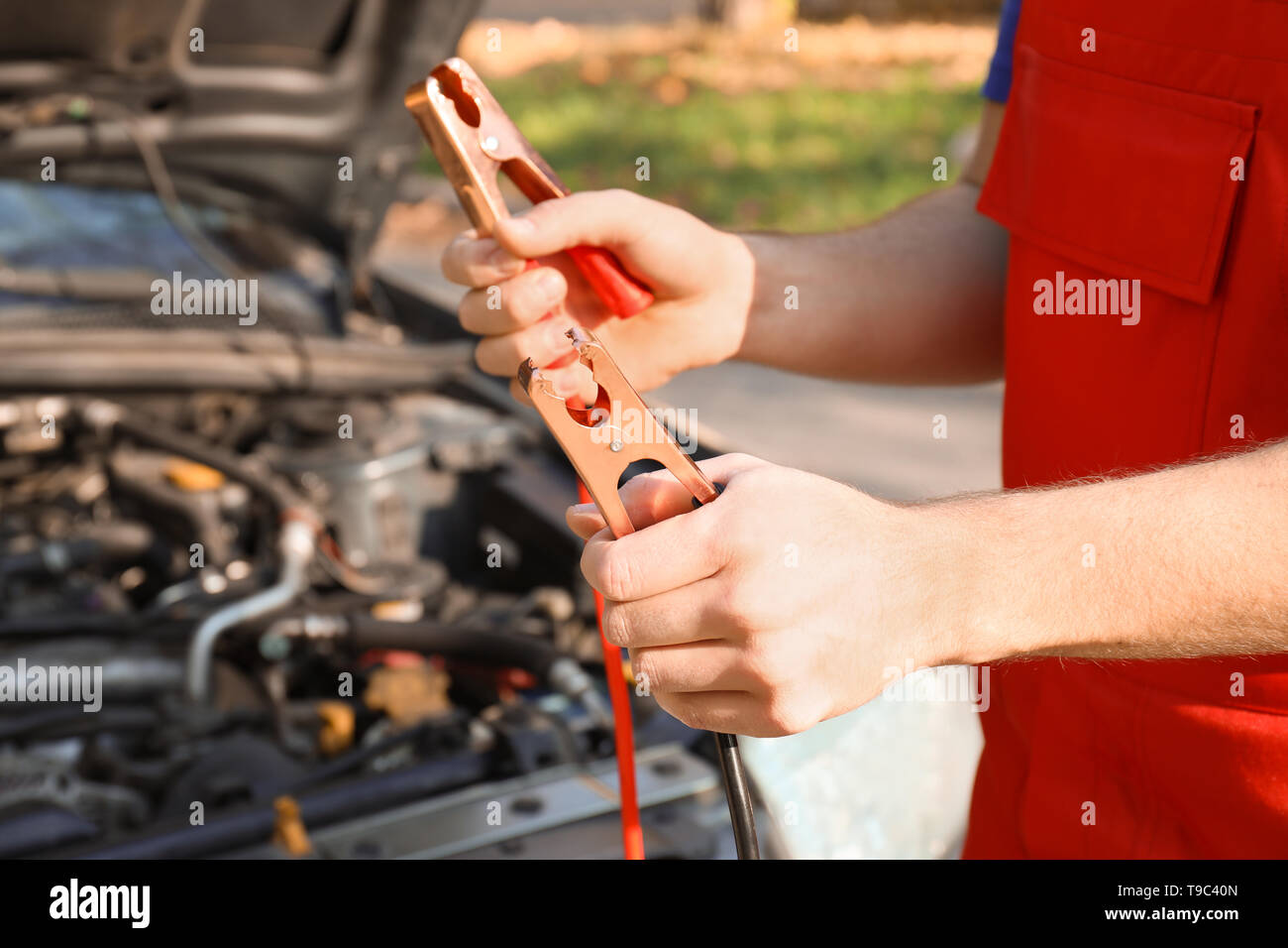 Male mechanic charging a car battery Stock Photo - Alamy