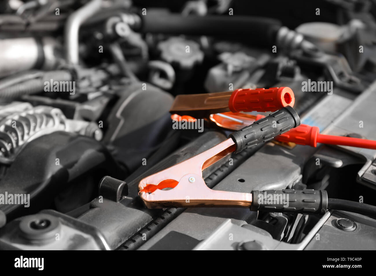 Battery charger under open hood of car Stock Photo - Alamy