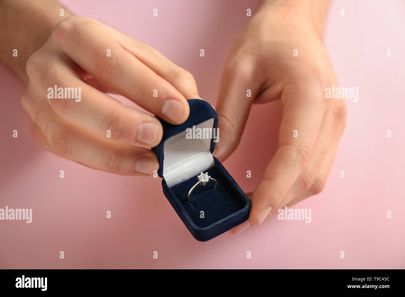 Male hands holding box with engagement ring on color background Stock ...