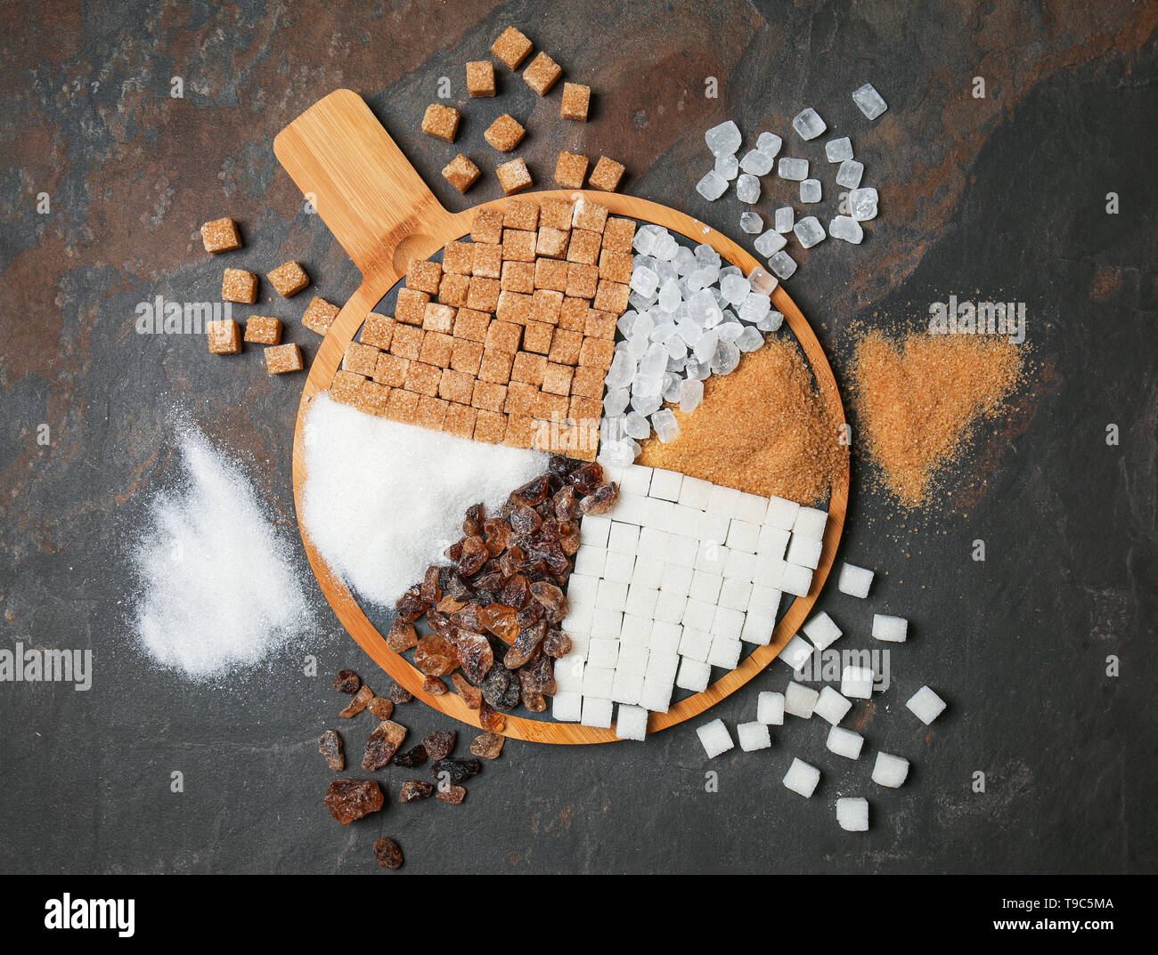 Wooden board with different kinds of sugar on grey background Stock ...