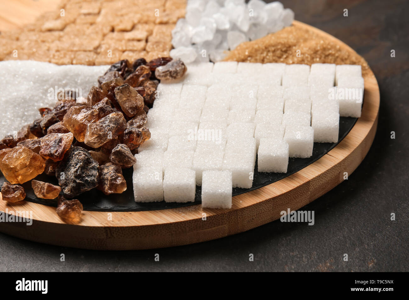Wooden board with different kinds of sugar on grey background Stock ...