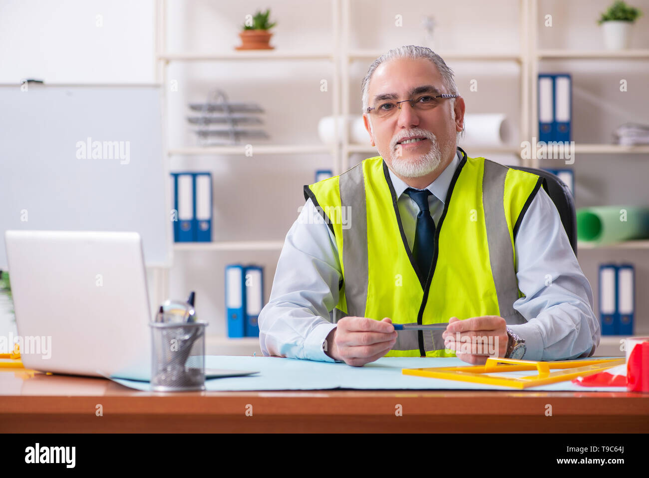 Aged construction engineer working in the office Stock Photo - Alamy