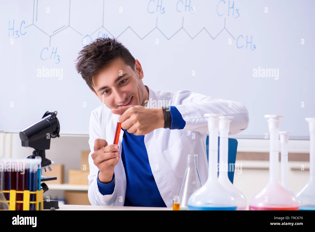 Happy young chemist mixing hi-res stock photography and images - Alamy