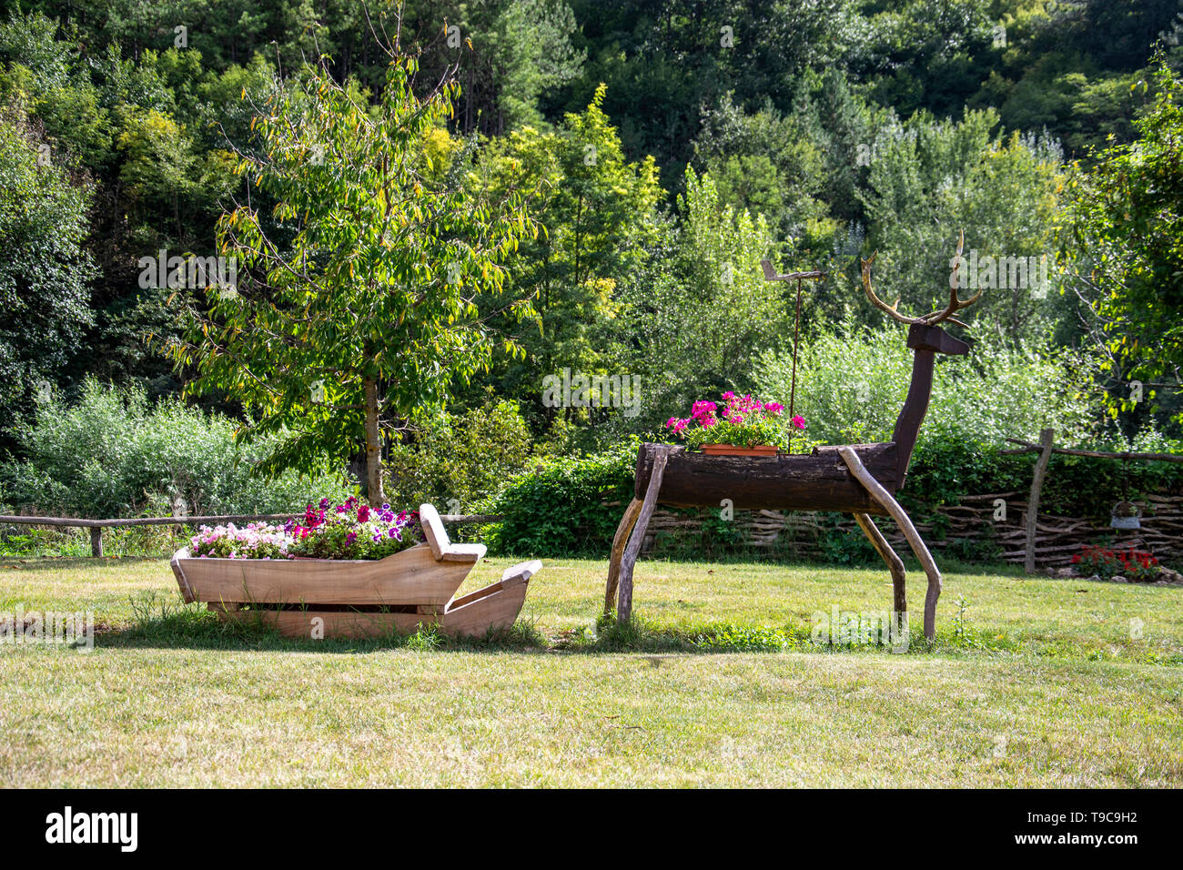 wooden reindeer on the grass,against forest on summer Stock Photo - Alamy