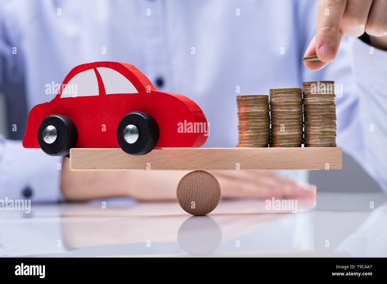 Man's Hand Placing Coin On Top Of The Stack Coins And Red Car Over ...