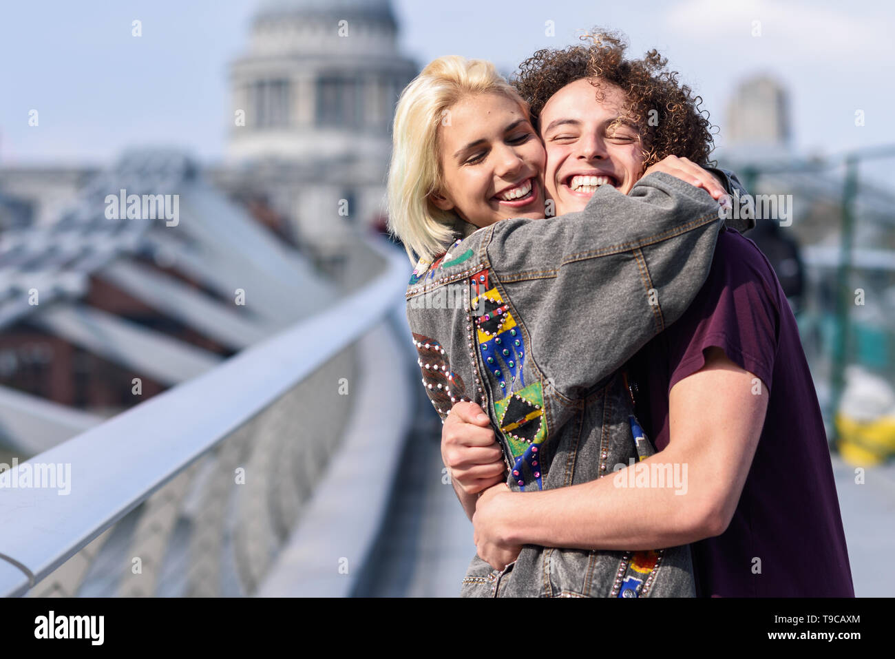 Happy couple hugging by Millennium bridge, River Thames, London Stock ...