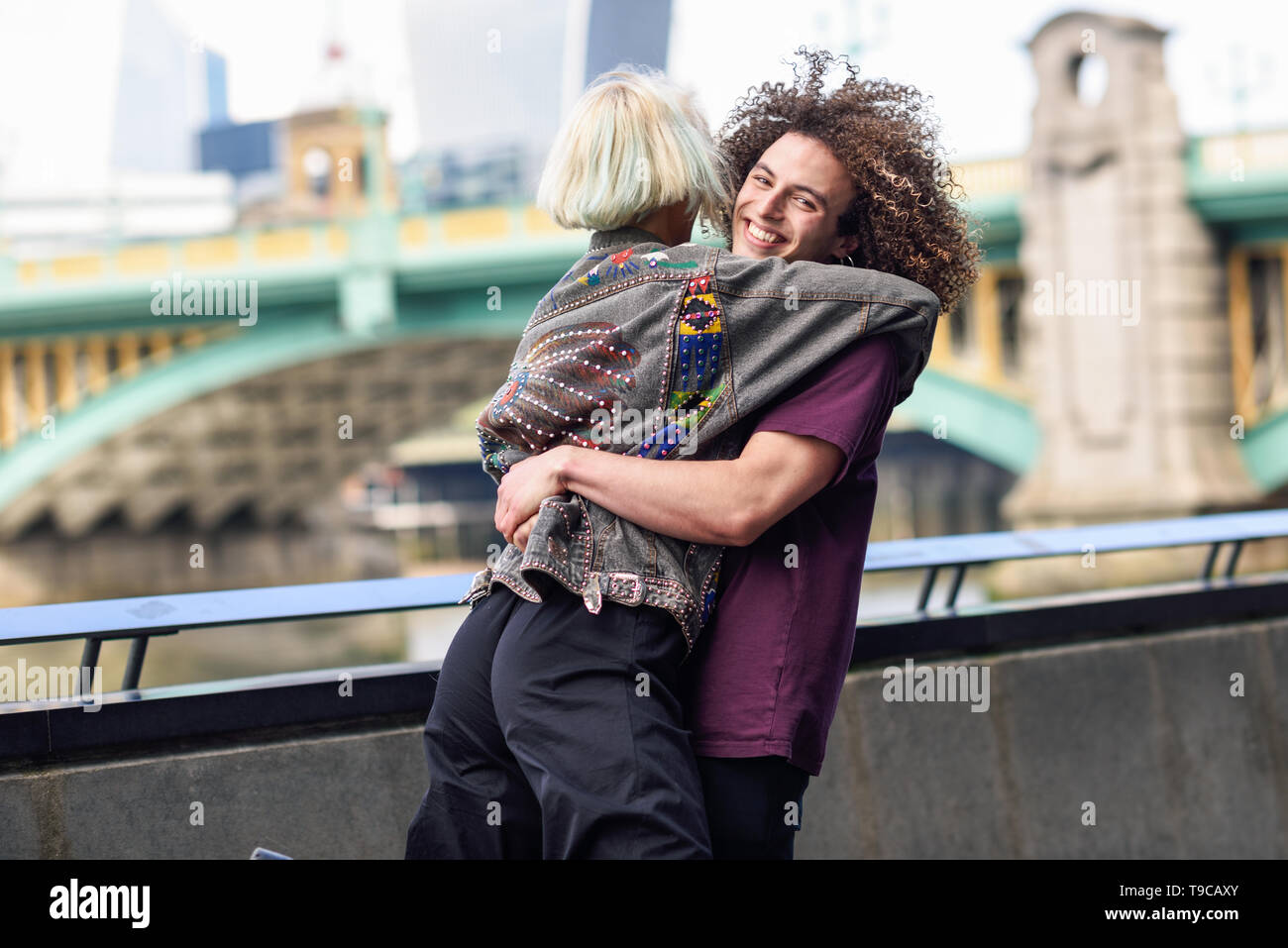 Happy couple hugging near the Southwark bridge over River Thames ...