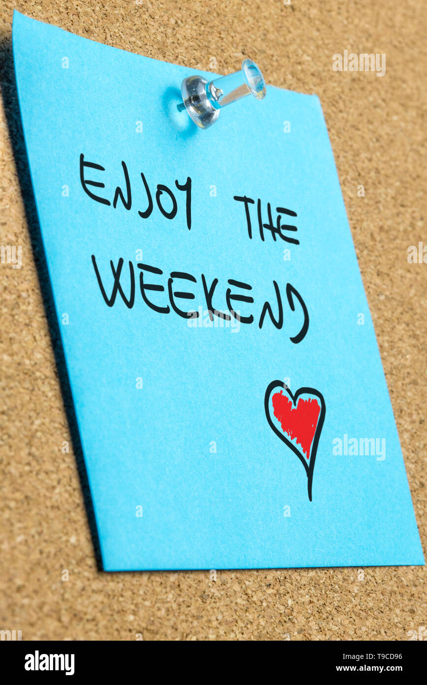 Perspective close-up of a blue reminder with handwritten wish to enjoy ...