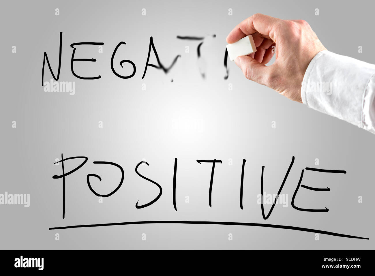 Man erasing Negative over Positive on a white screen in a conceptual ...