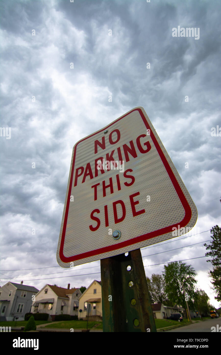No Parking This Side sign with dark storm clouds in the background ...