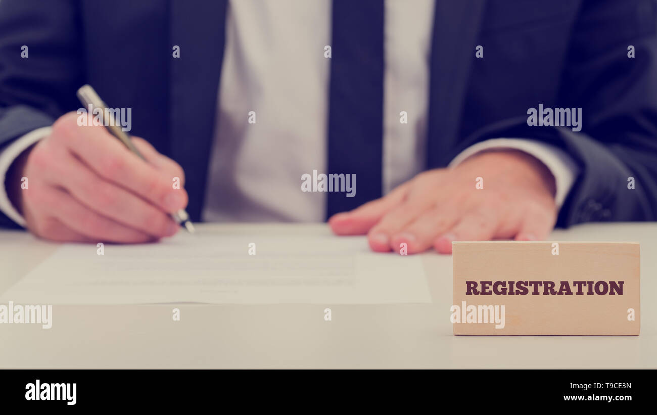 Close up Registration Text on Small Wooden Piece In Front Businessman ...