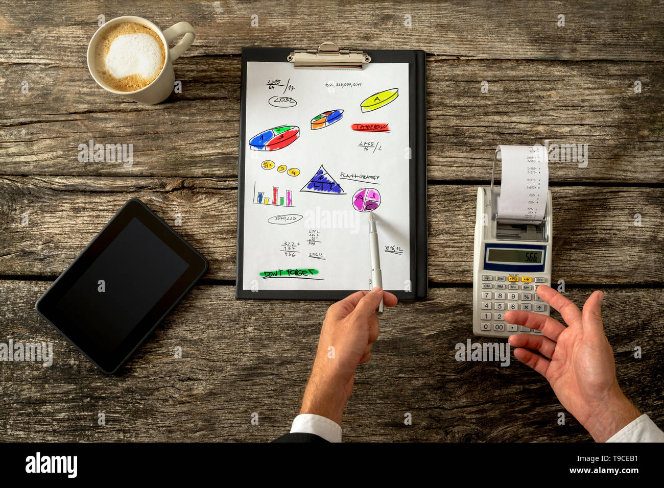 Top view of male accountant doing calculations using adding machine as ...
