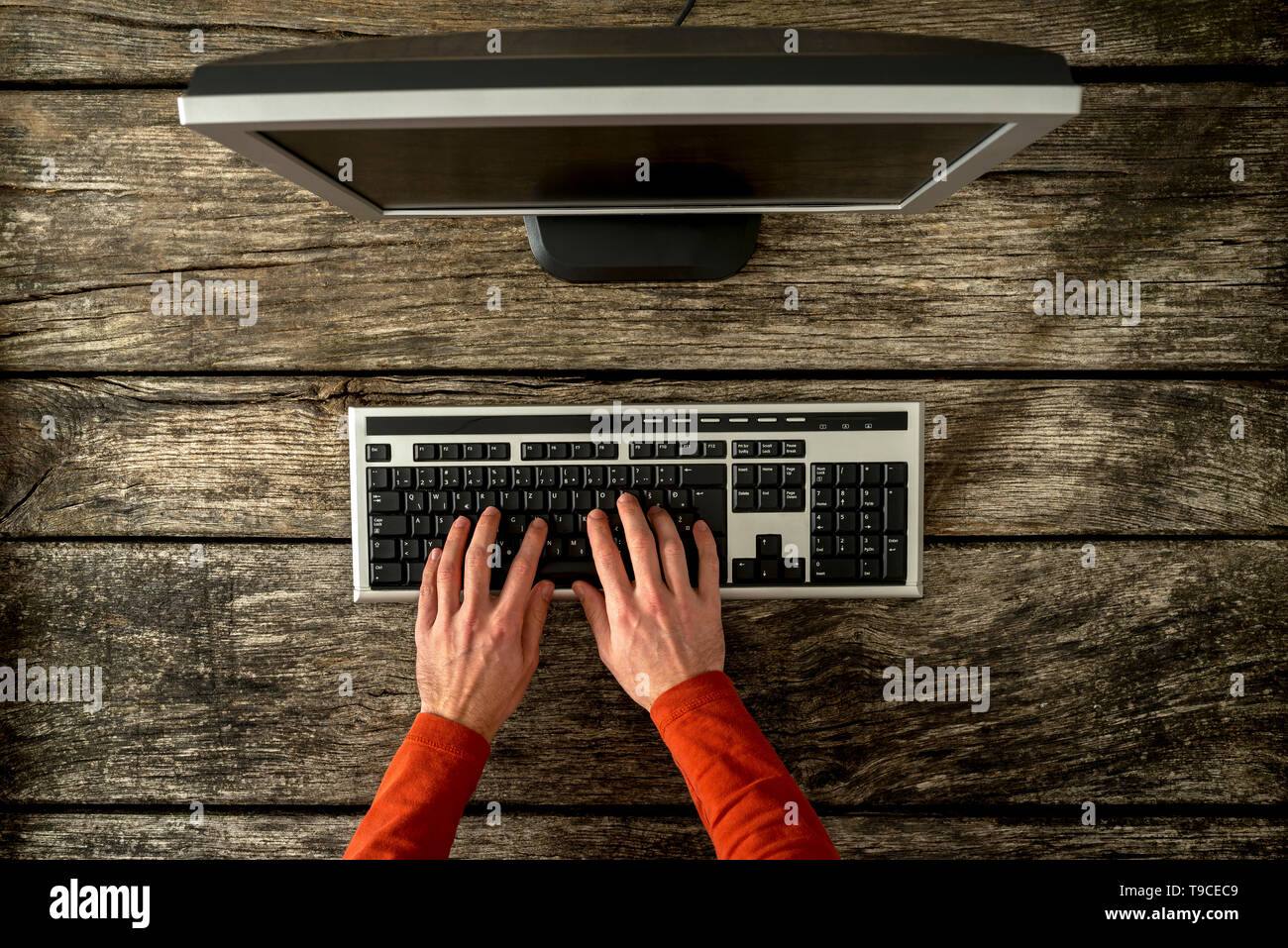 Top view of male hands typing on personal computer keyboard lying on a ...