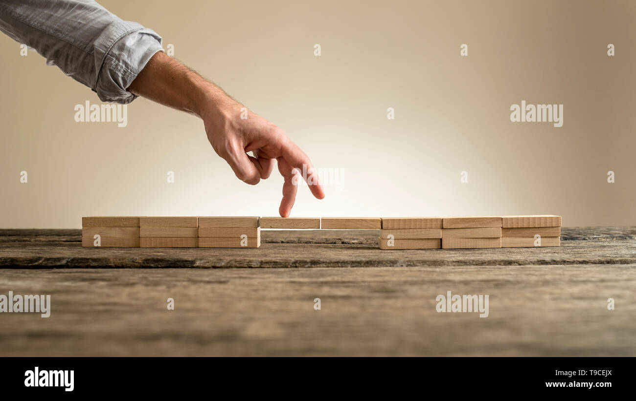 Man hand showing walking fingers over fragile bridge of wooden bricks ...