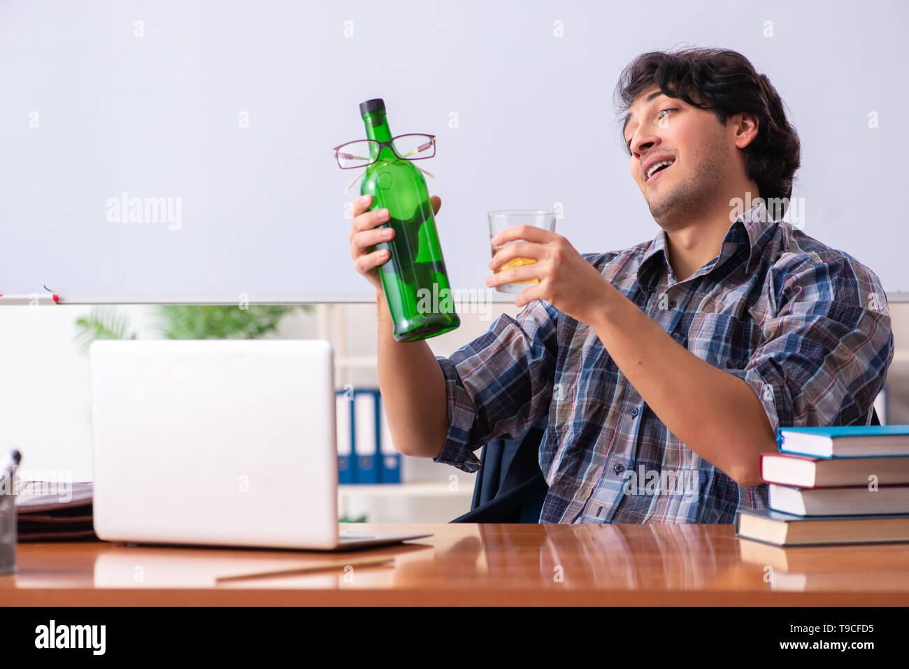 Male teacher drinking in the classroom Stock Photo - Alamy