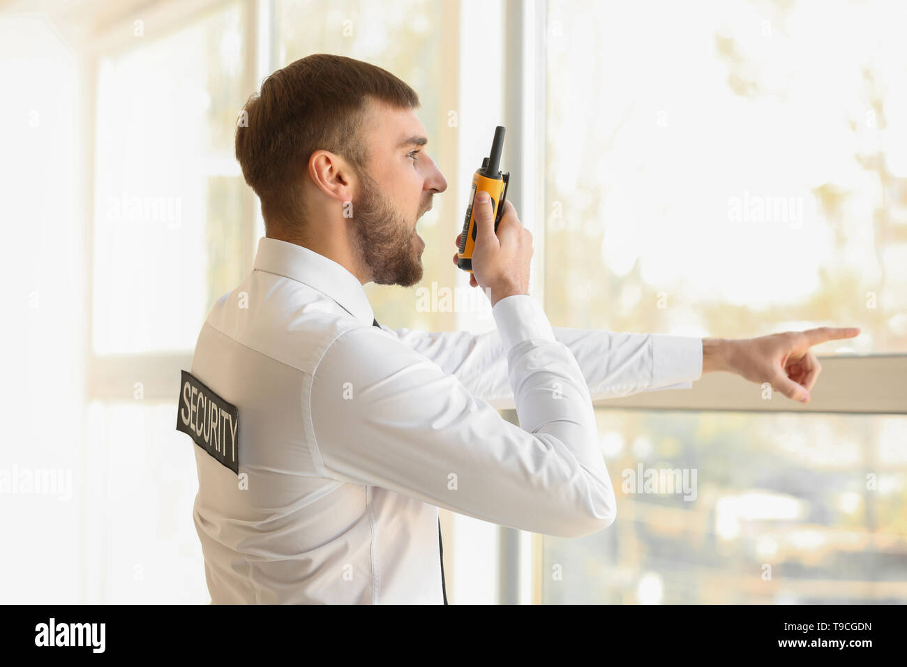 Male security guard with portable radio transmitter indoors Stock Photo ...