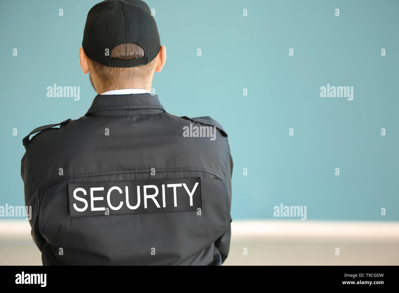 Male security guard indoors, back view Stock Photo - Alamy