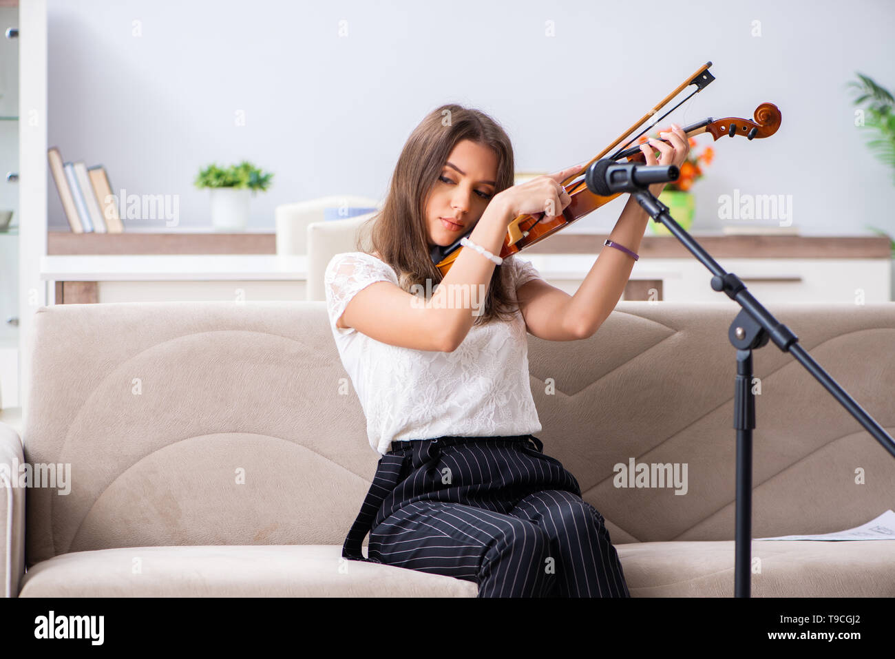 Female beautiful musician playing violin at home Stock Photo - Alamy