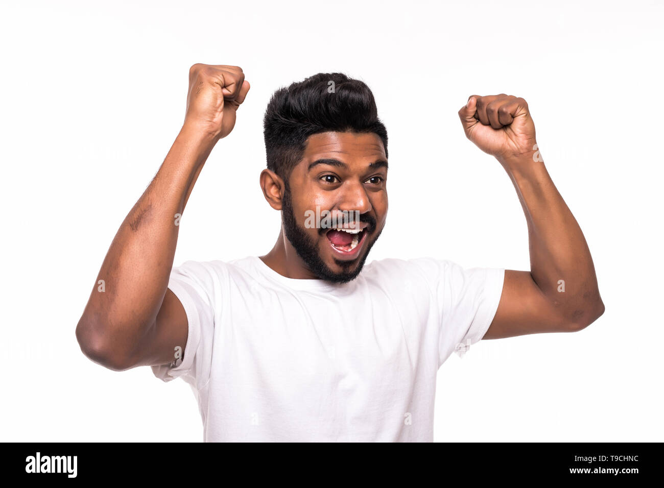 Happy young Indian man gesturing and smiling while standing against ...