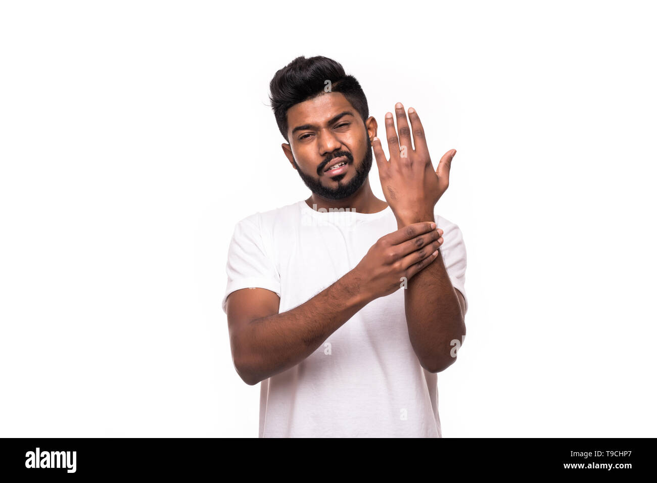 Handsome indian man having an arms pain isolated on white background ...