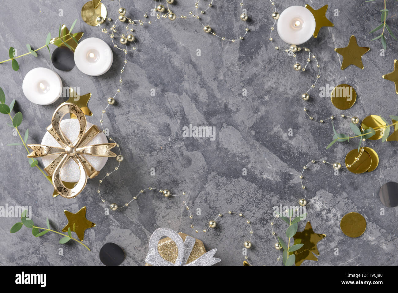 Frame made of burning candles with eucalyptus branches and gift boxes ...