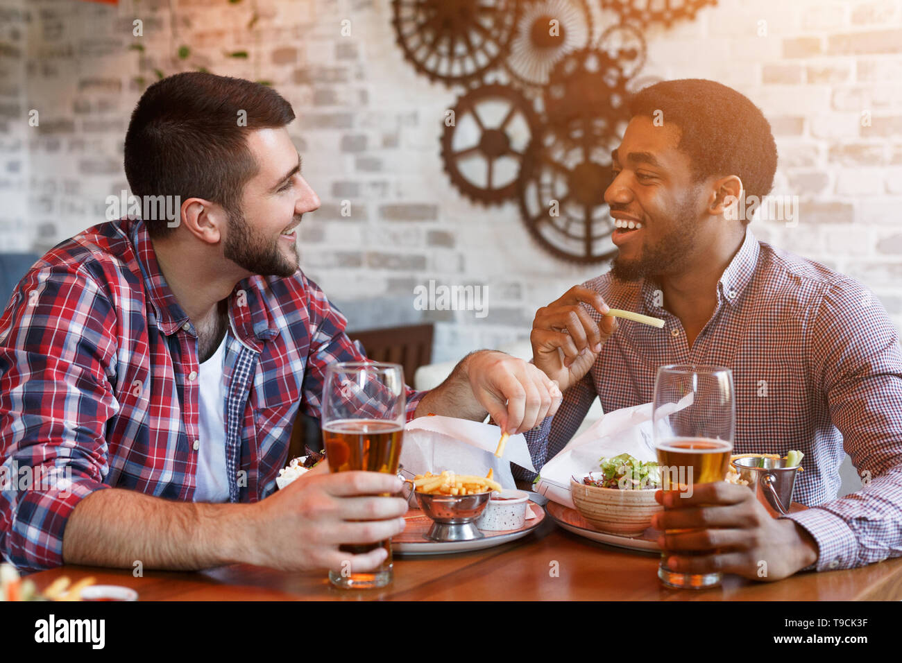 Rest In Bar. Men Drinking Beer And Eating French Fries Stock Photo - Alamy