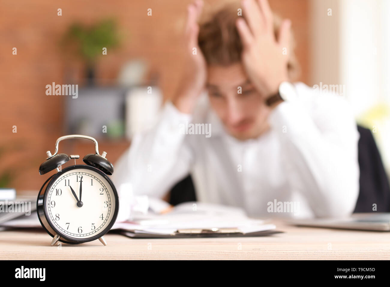 Alarm clock on table of stressed businessman missing deadlines Stock ...