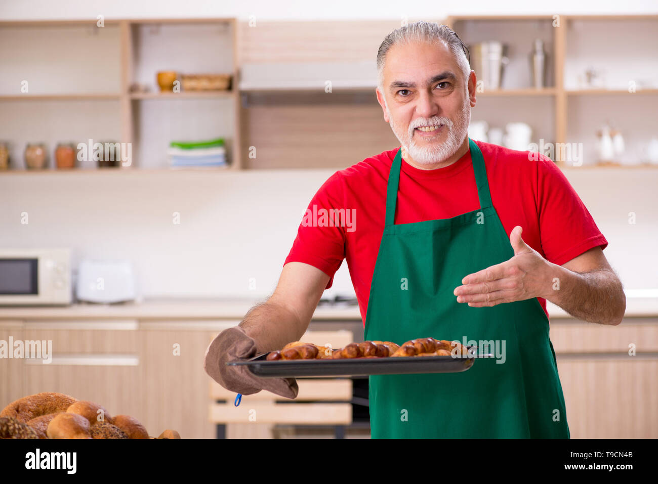 Old male baker working in the kitchen Stock Photo - Alamy