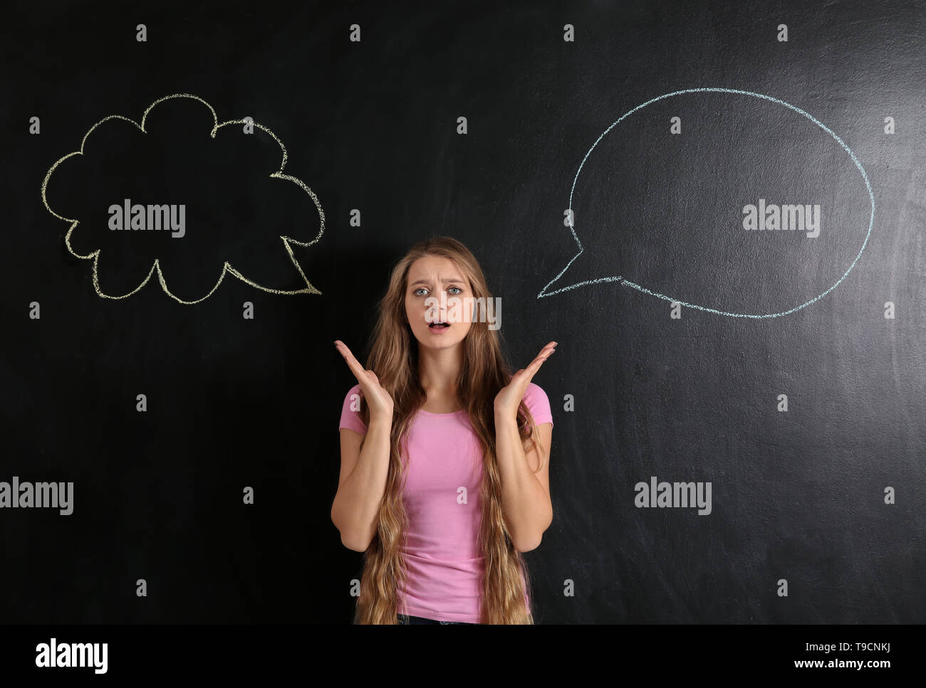 Confused young woman and blank speech bubbles on dark background Stock ...