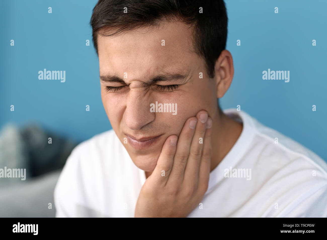 Young man suffering from toothache at home Stock Photo - Alamy